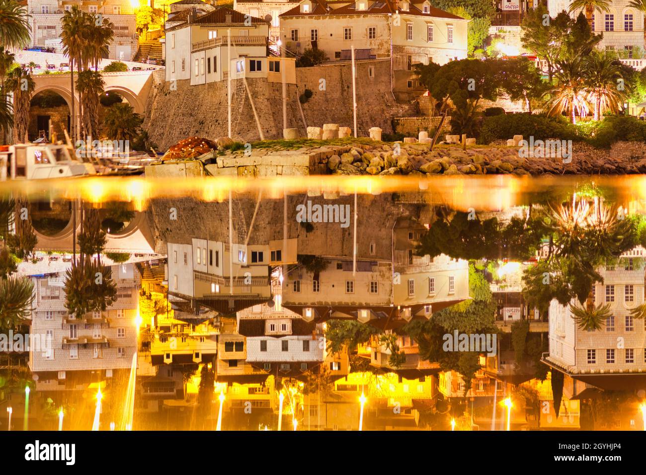 Beautiful view of an old town with lights reflected on the sea in ...