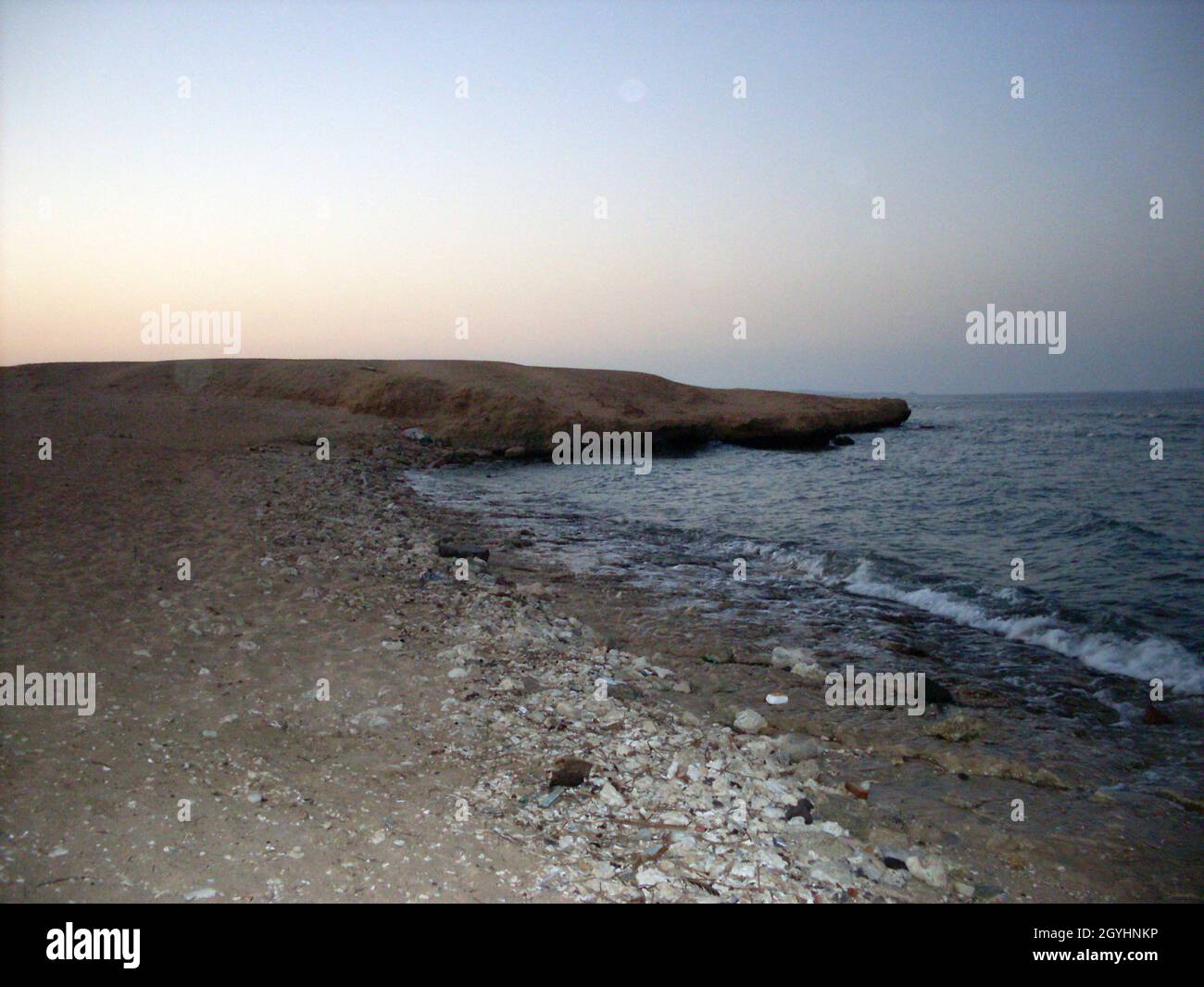 Beach at an egyptian resort at low tide with mountains in the ...