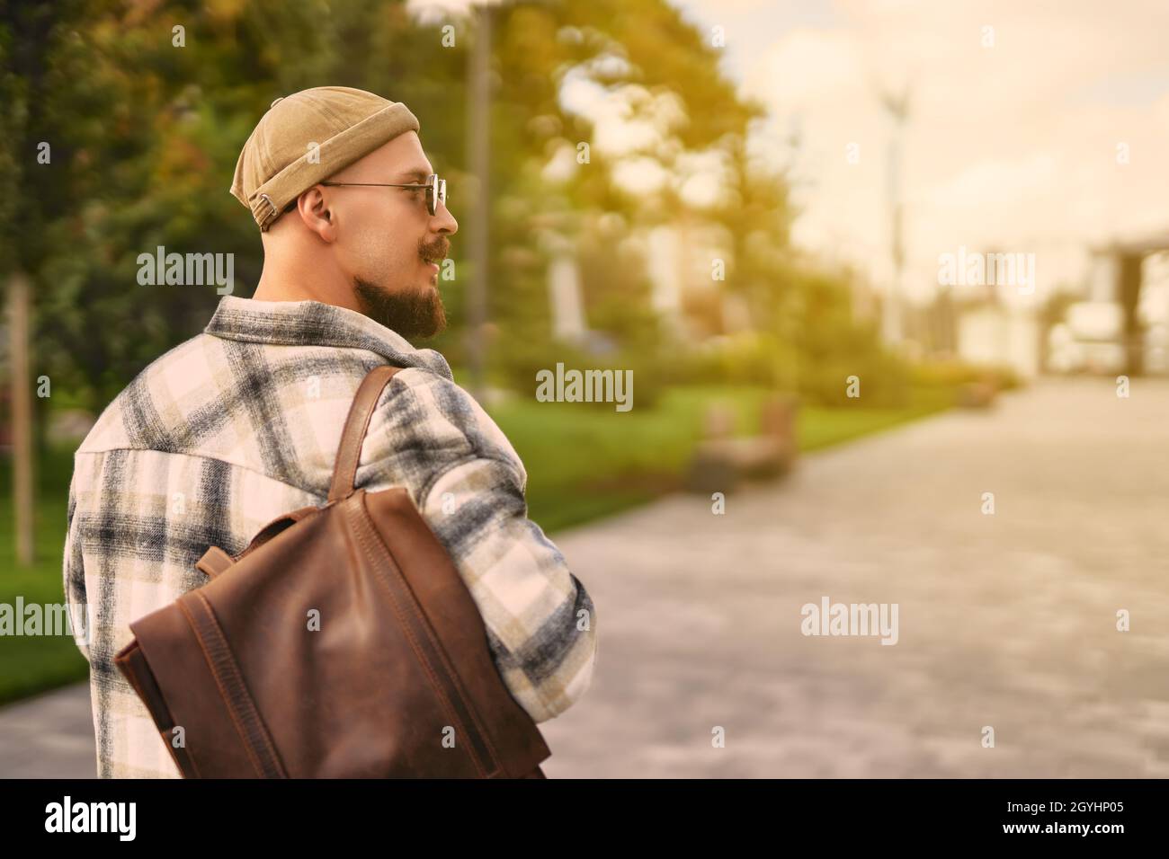Back view of hipster bearded student looks sideways while walks in ...