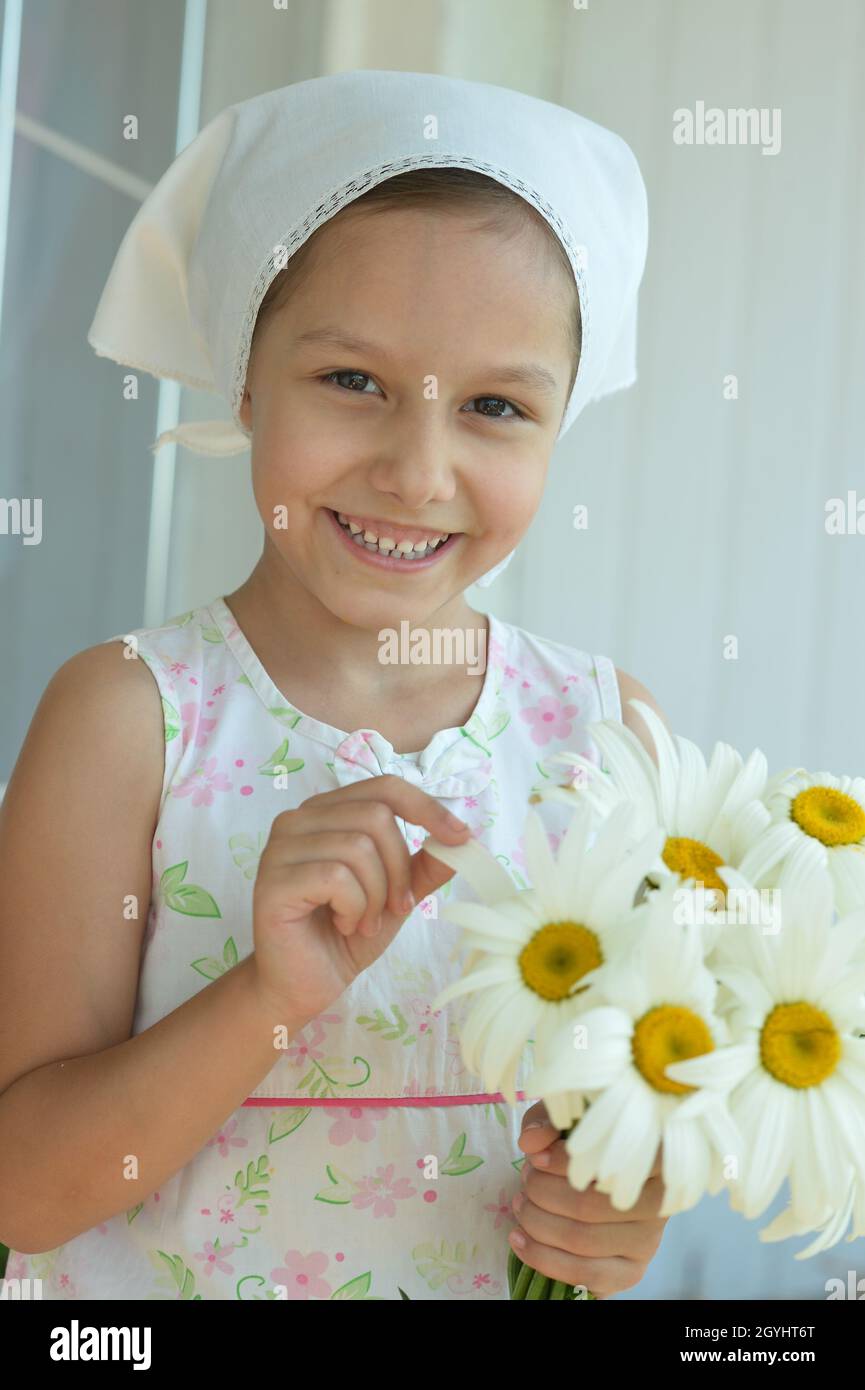 Cute little girl at home with chamomiles Stock Photo - Alamy