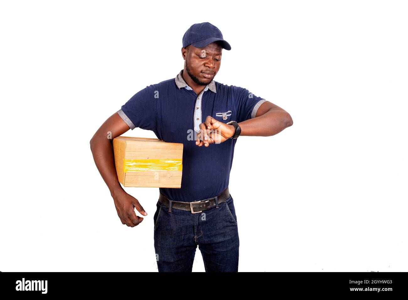 handsome young delivery man standing and looking at the time on his ...