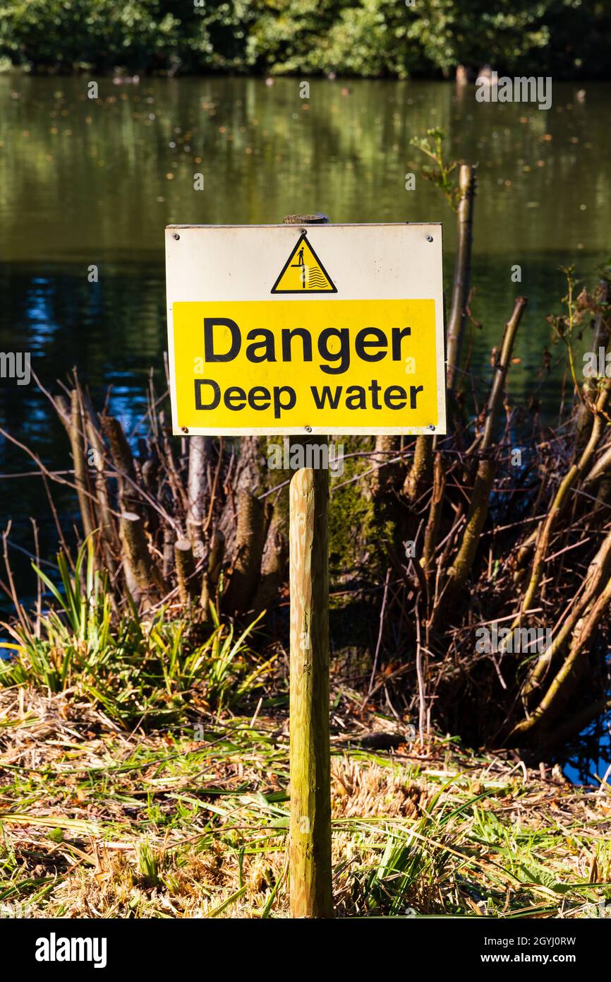 Danger deep water sign post with water behind Stock Photo - Alamy