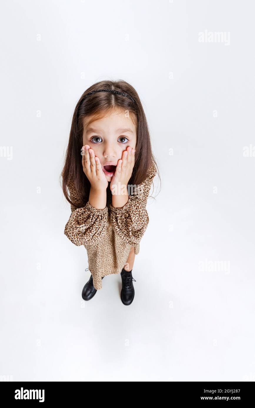 High angle view of little cute smiling preschool beautiful girl looking ...