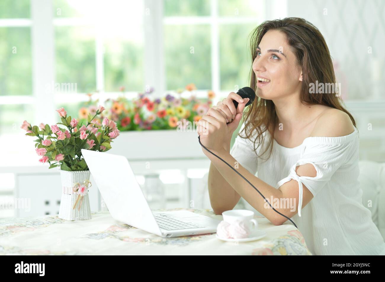 Beautiful young woman singing karaoke Stock Photo - Alamy