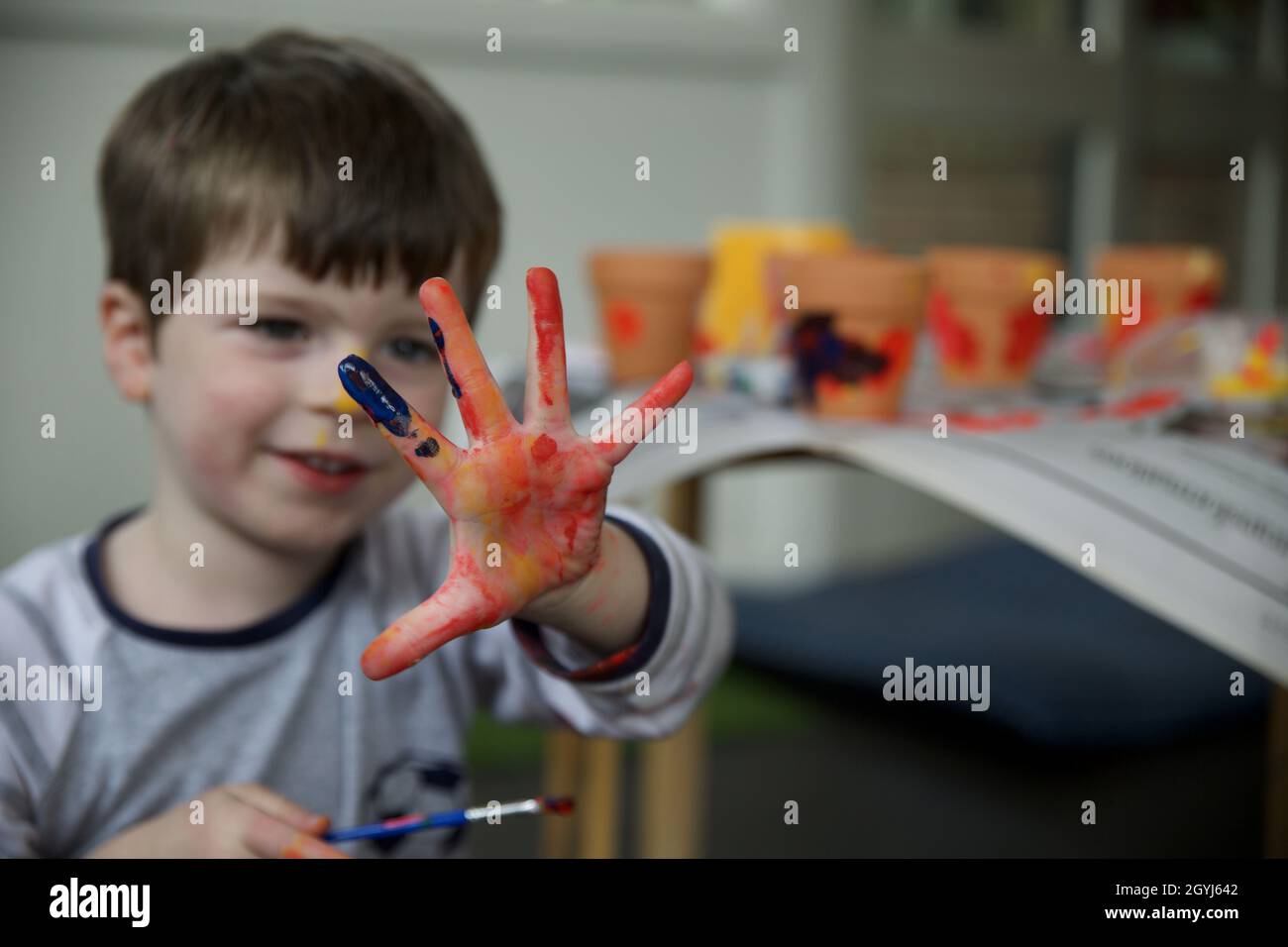 Happy toddler painting with messy hands Stock Photo - Alamy