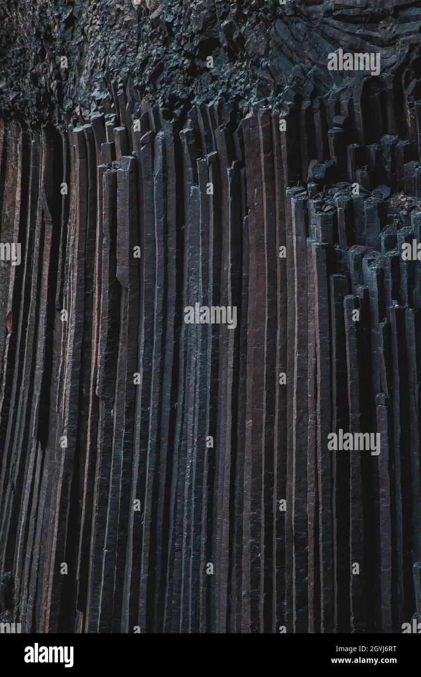 Vertical shot of dark basalt column formation - for backgrounds and ...