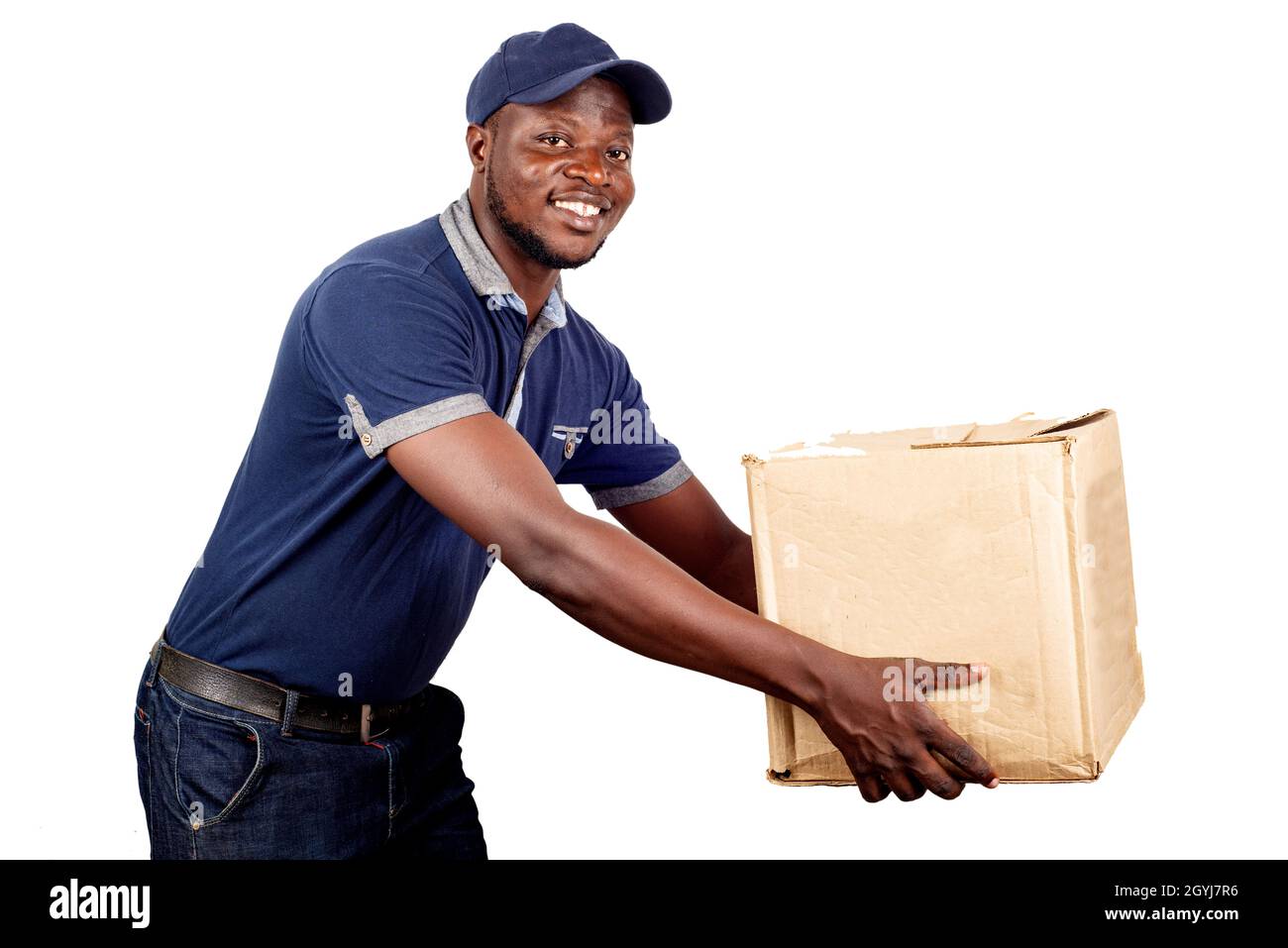 Young delivery man standing in uniform on white background carrying a ...