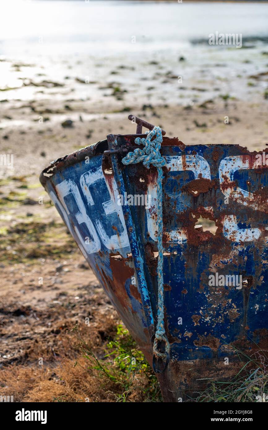 rusty corroded old fishing boat rotting away on the shoreline at ...