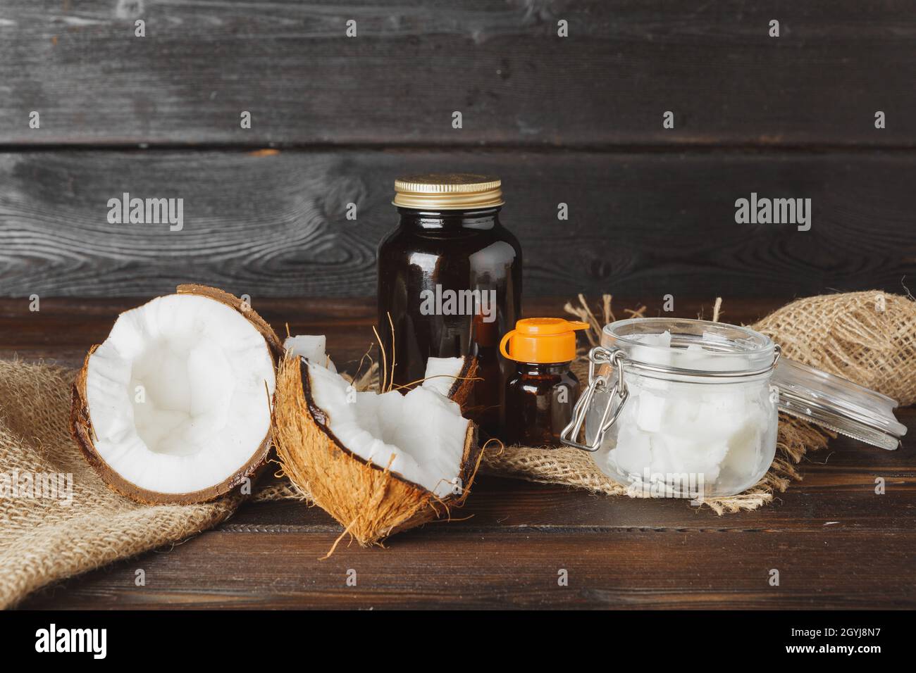 Broken coconut on a dark aged wooden table close up Stock Photo - Alamy