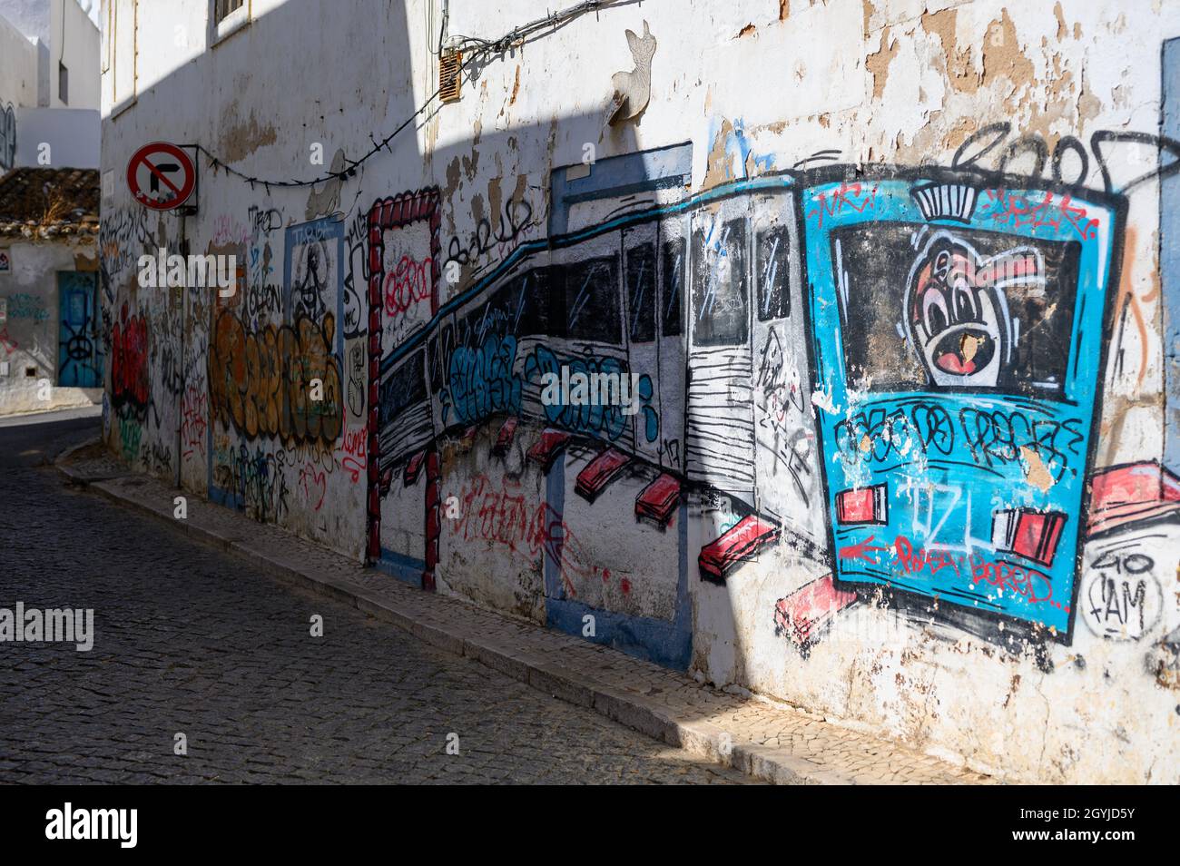 Some street art graffiti in a small mediterranean city in warm sunlight ...