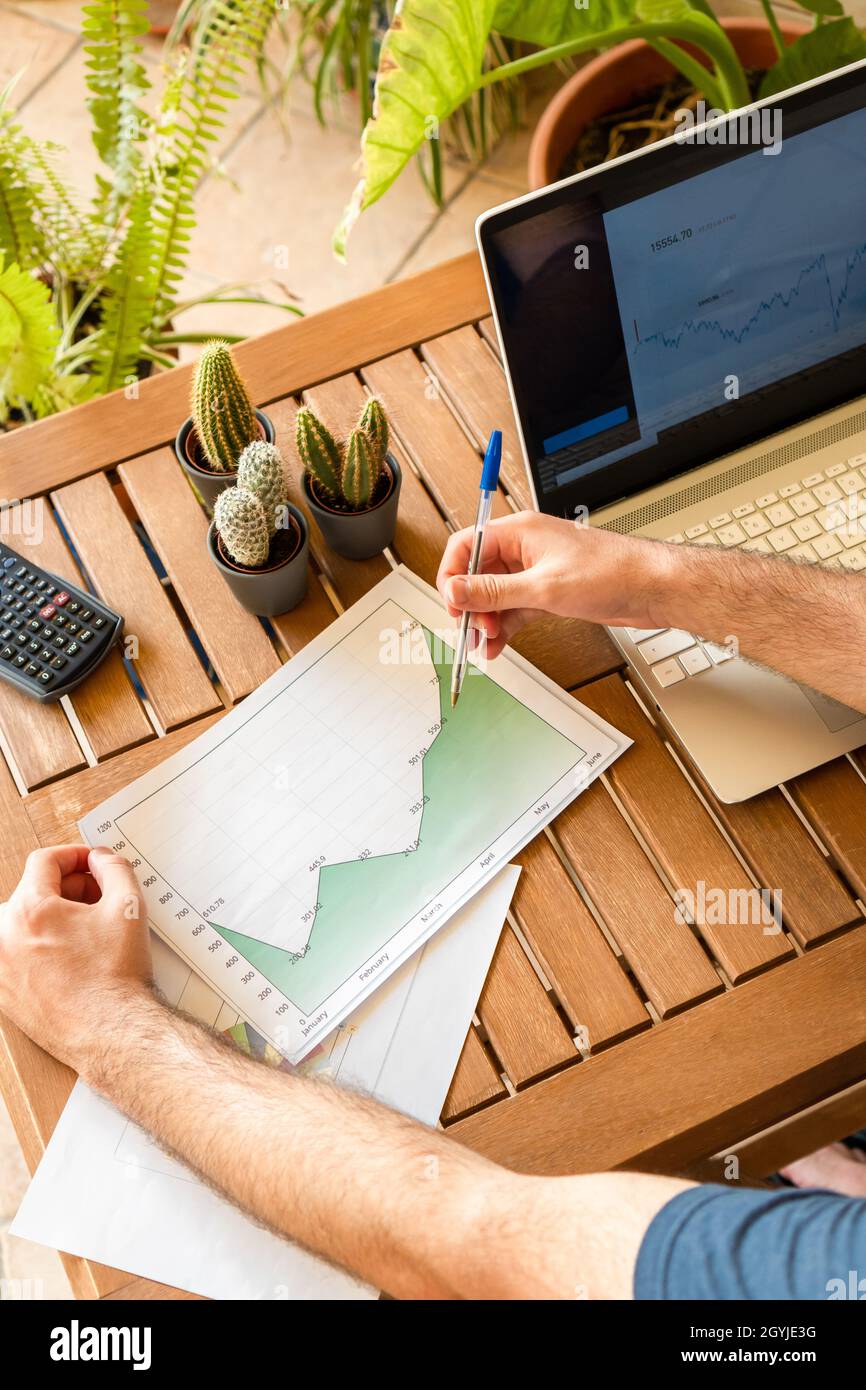 Top view of broker analyzing charts on desk with a computer while ...
