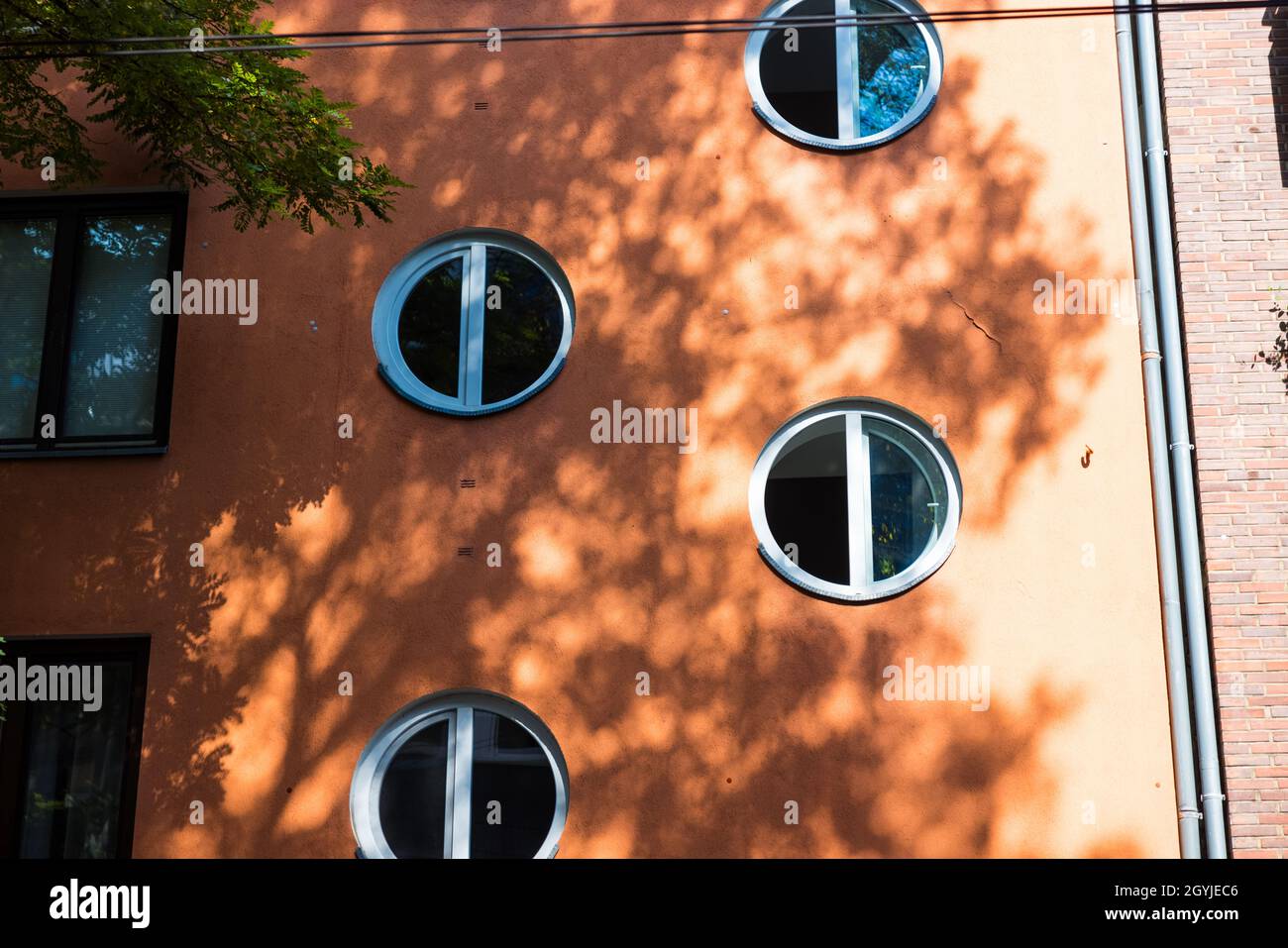 Orange building facade with round windows Stock Photo - Alamy