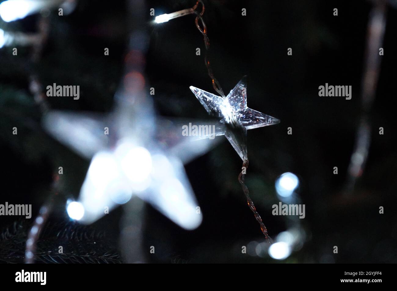 White lights on the Christmas tree. Star shaped decoration. Bright ...