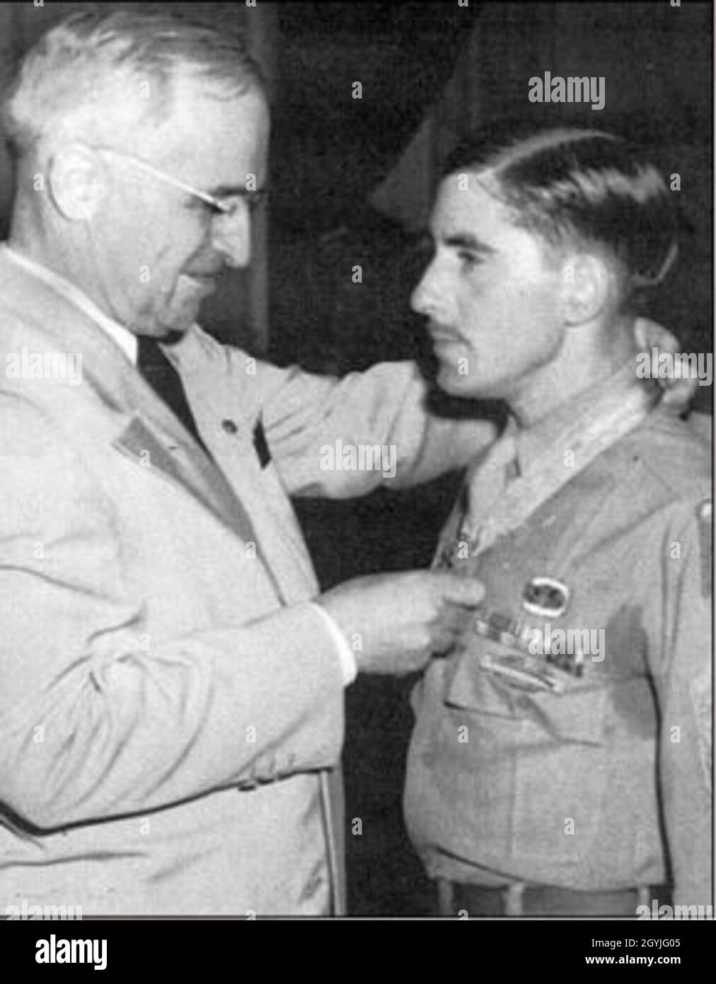 President Harry S. Truman places the Medal of Honor around the neck of ...