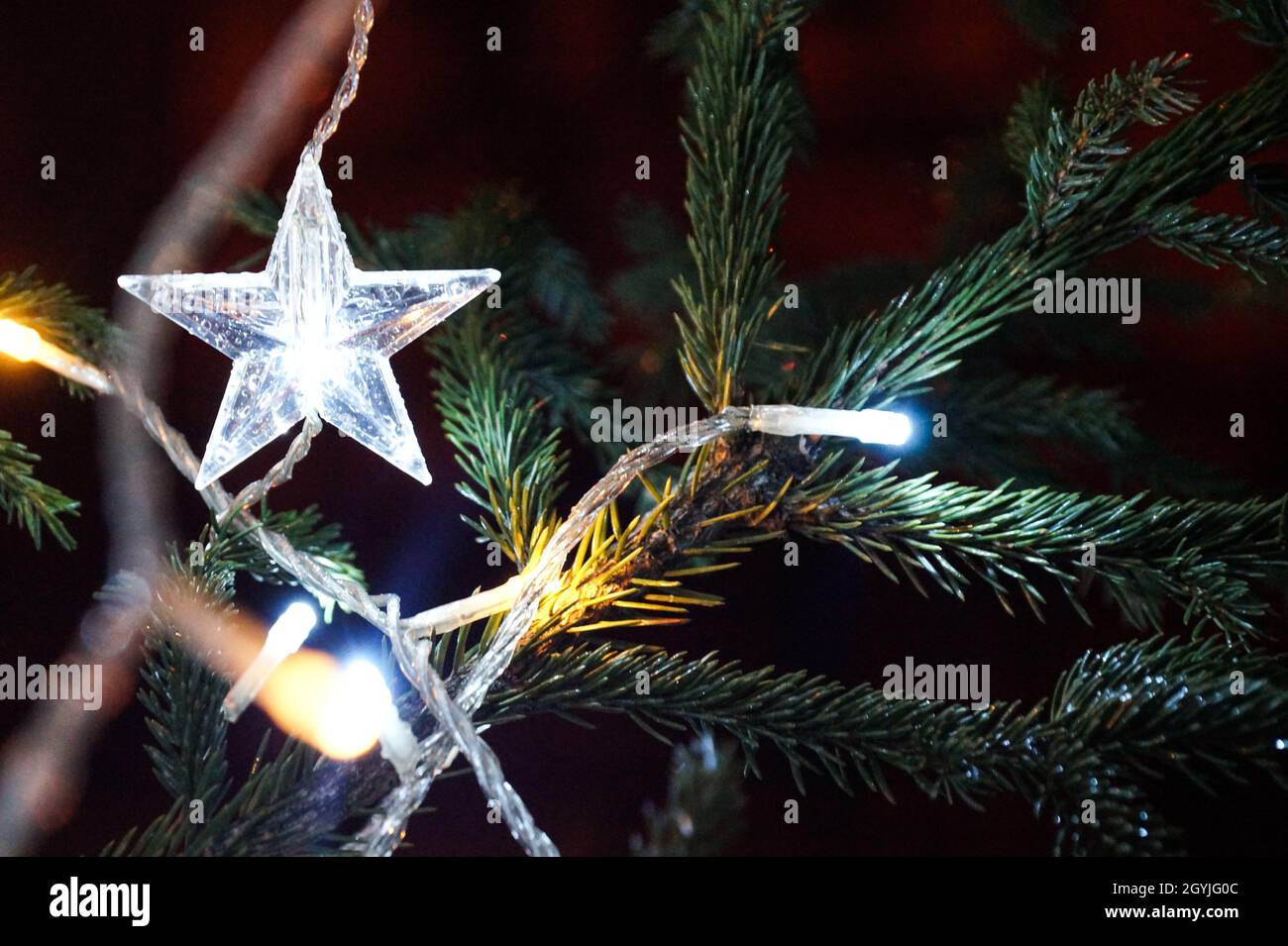 White lights on the Christmas tree. Star shaped decoration. Bright ...
