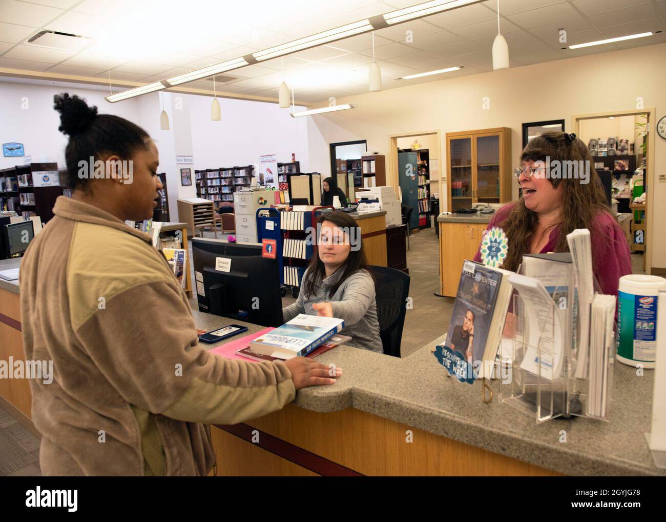 Shayla Tait, library patron, checks out books from Roxanne Bangs, 366th ...