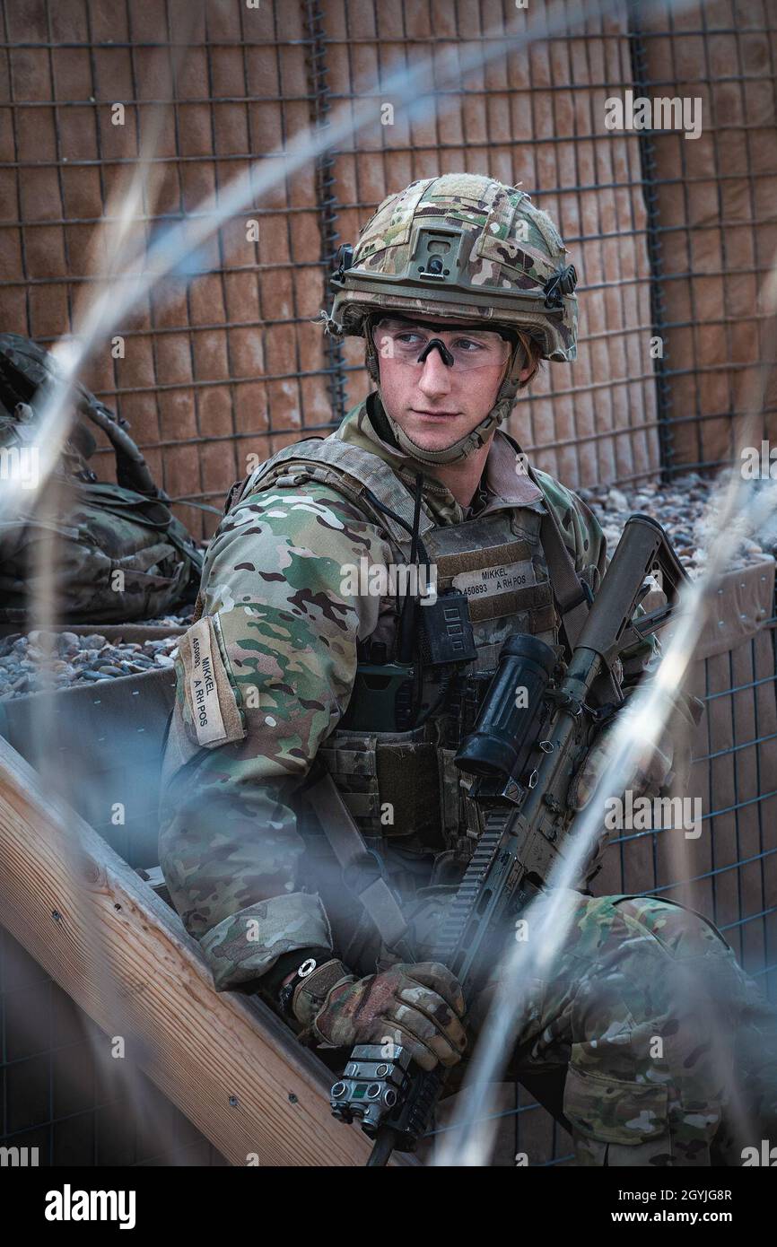 A Danish soldier observes his sector of fire during a base defense ...