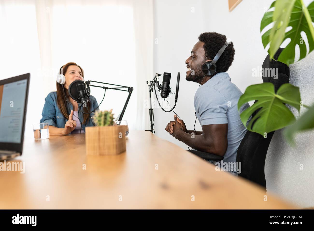 Multiracial people recording a podcast using microphone and laptop from ...
