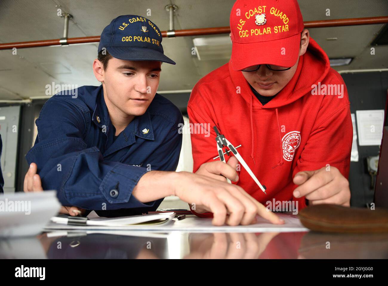 U.S. Coast Guard Petty Officer 3rd Class Caleb Garrett (left) explains ...