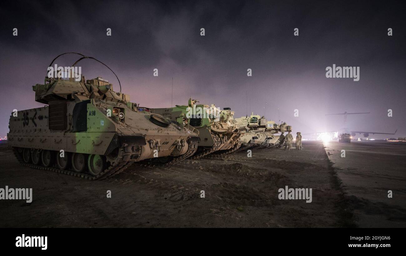 U.S. Army M2 Bradley Fighting Vehicles and M1A1 Abrams tanks are parked ...