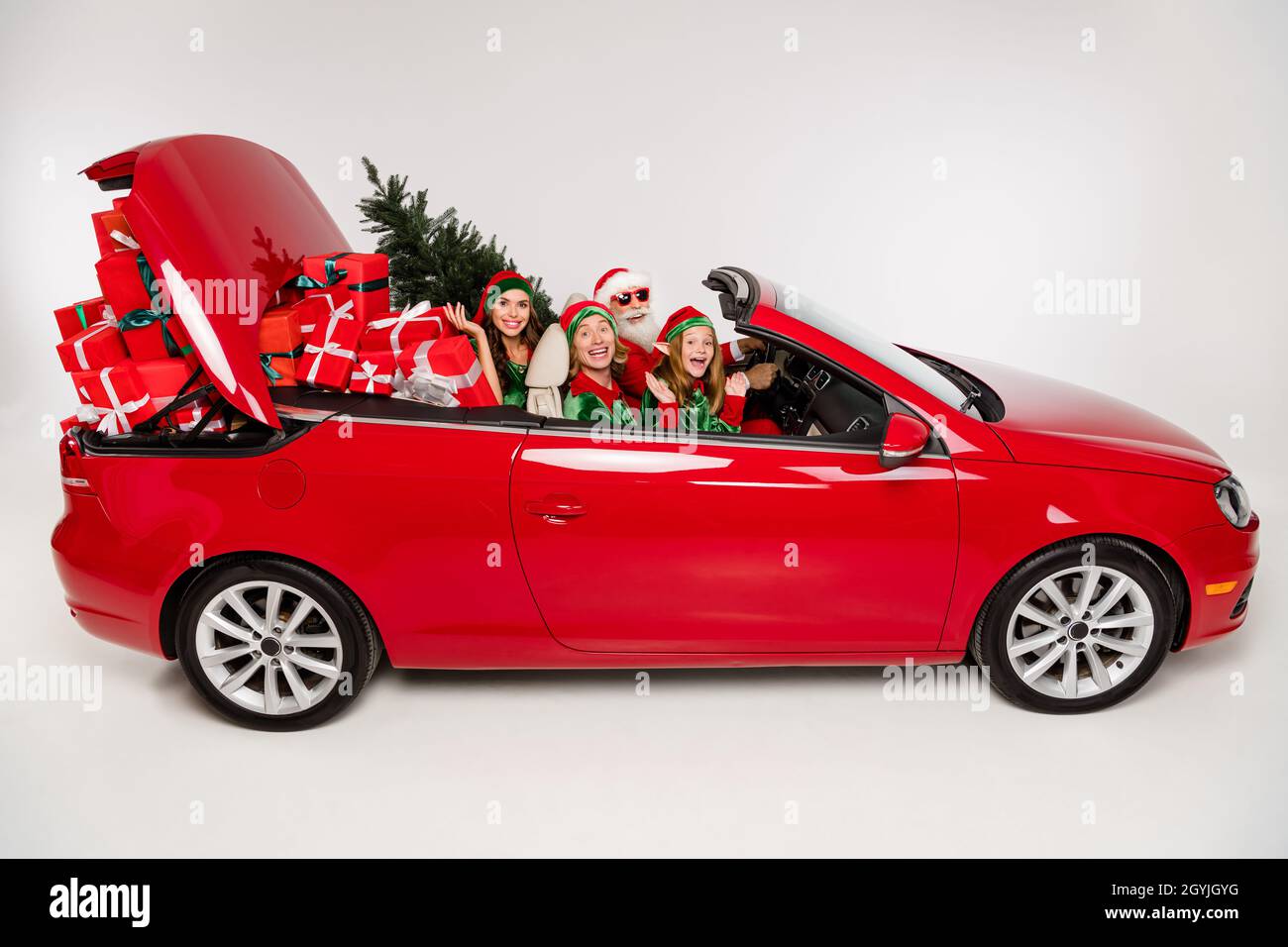 Photo of charming pretty santa claus helpers riding car delivering ...