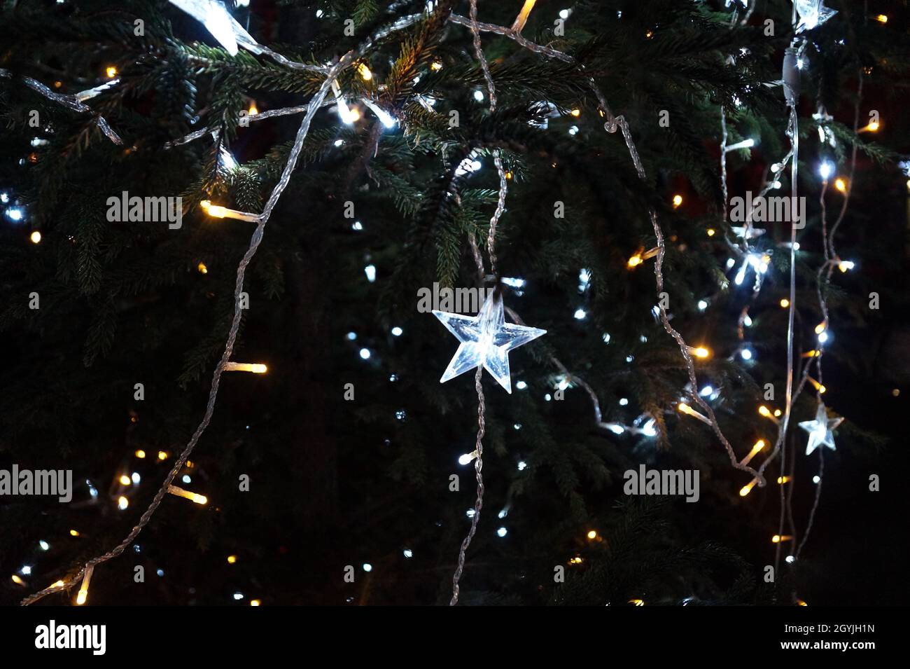White lights on the Christmas tree. Star shaped decoration. Bright ...
