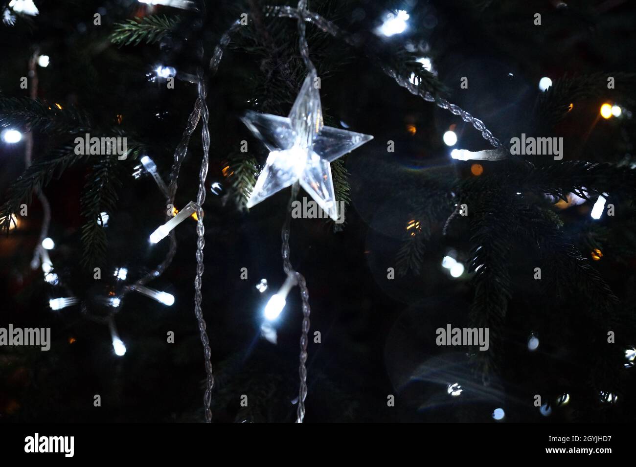 White lights on the Christmas tree. Star shaped decoration. Bright ...