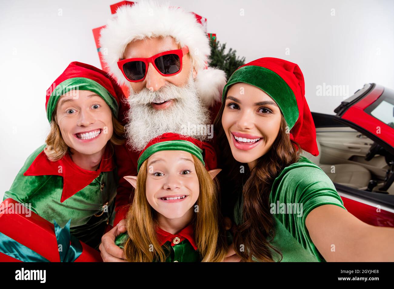 Photo of cute charming santa claus assistants driving car recording ...