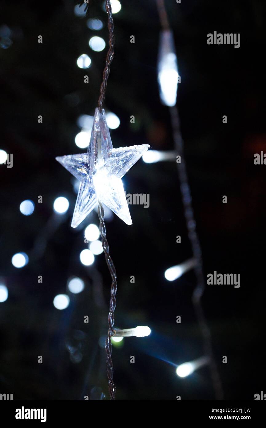 White lights on the Christmas tree. Star shaped decoration. Bright ...