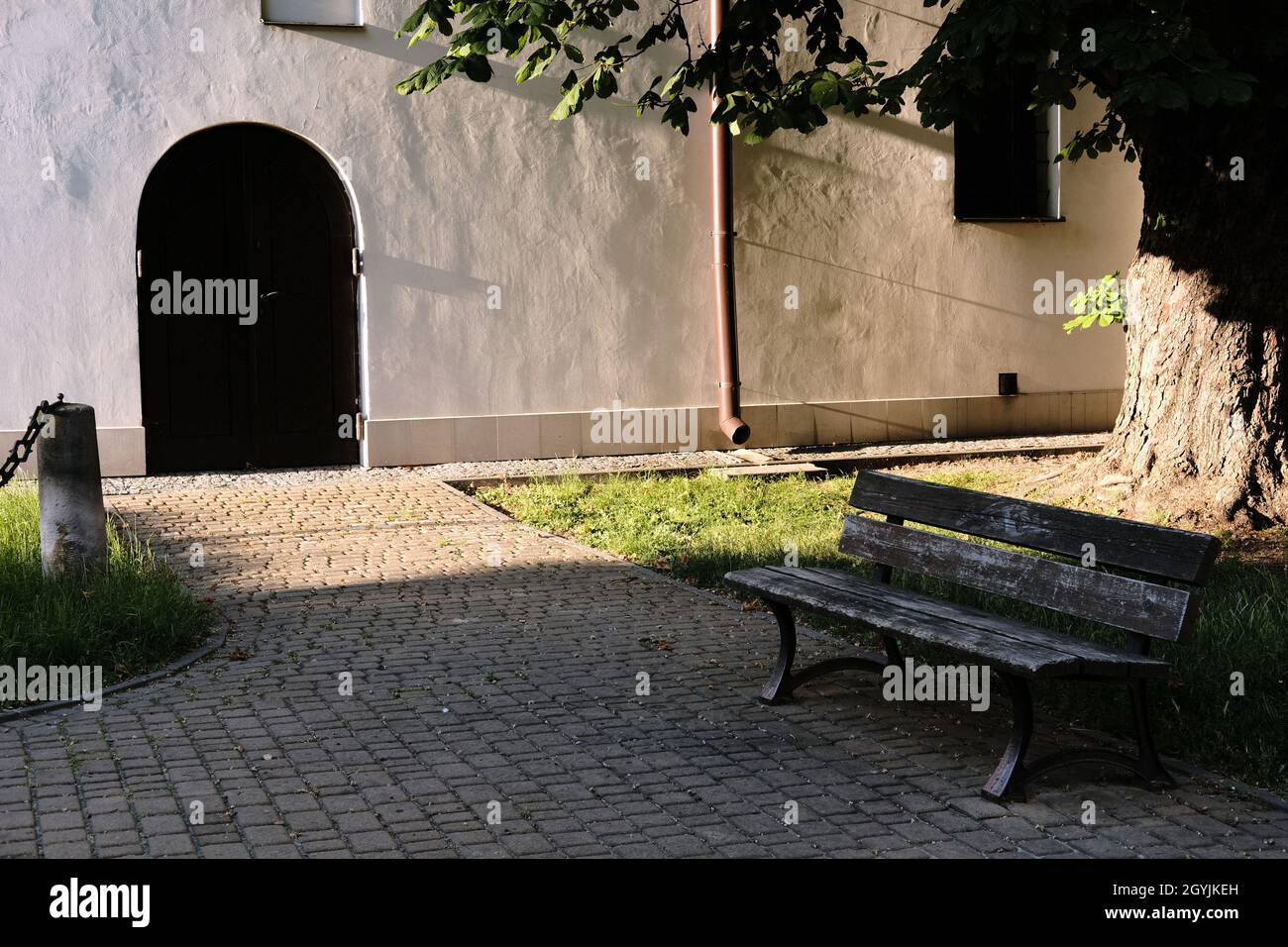 old church courtyard with beautiful old tree and shadows cast by ...