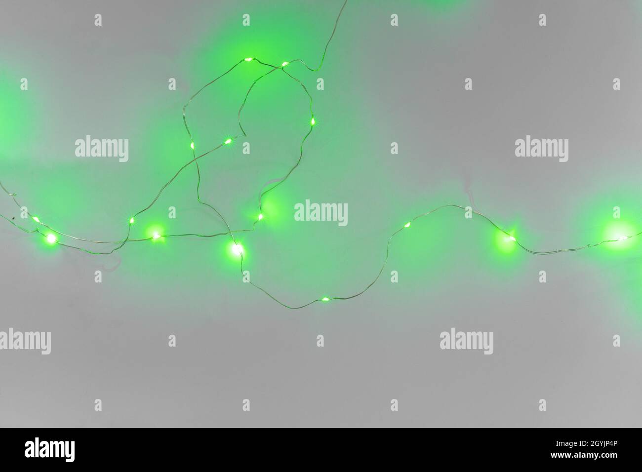 Green color illuminated garland on light gray background Stock Photo ...