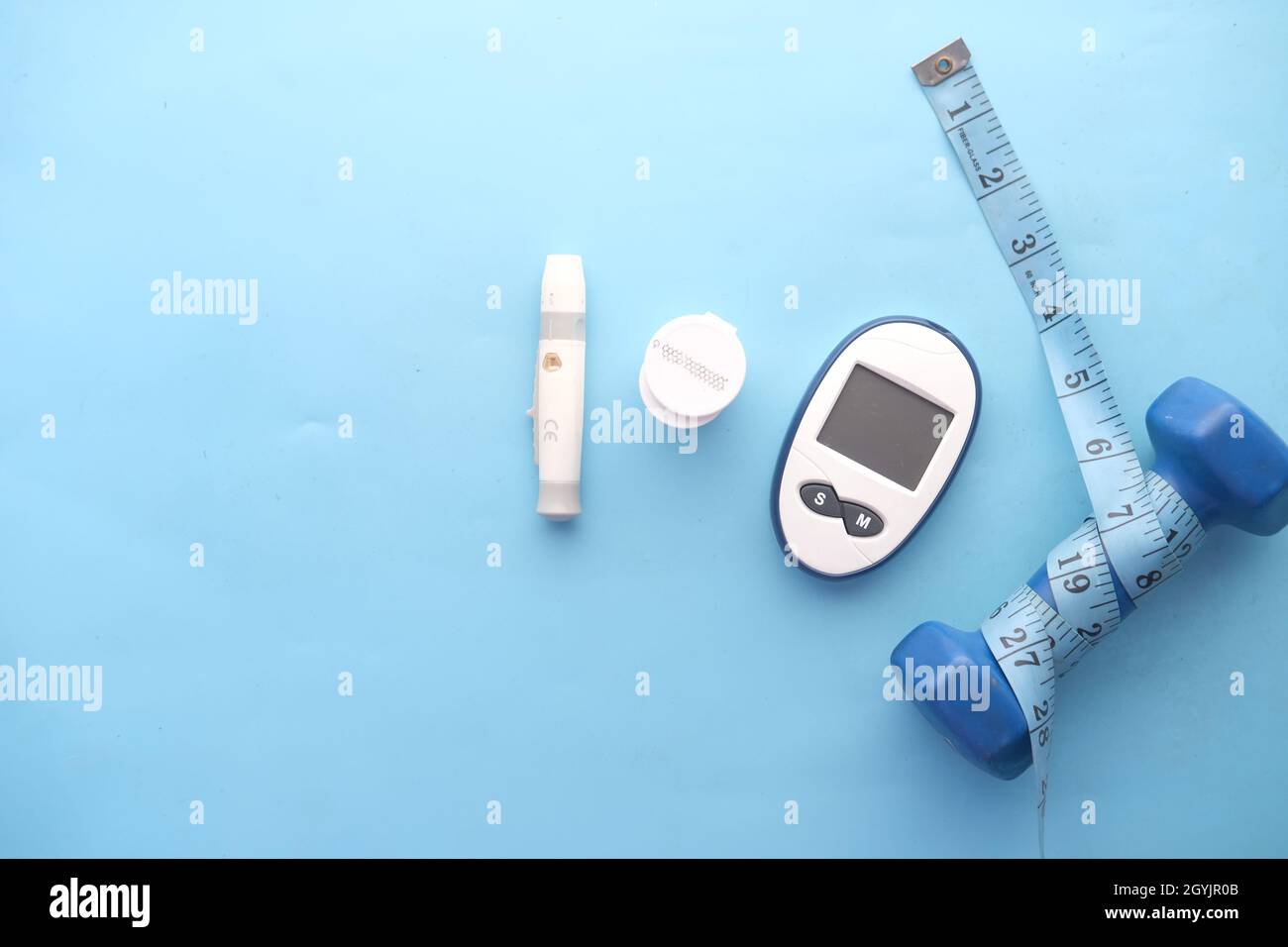 diabetic measurement tools and a dumbbell on blue background Stock ...
