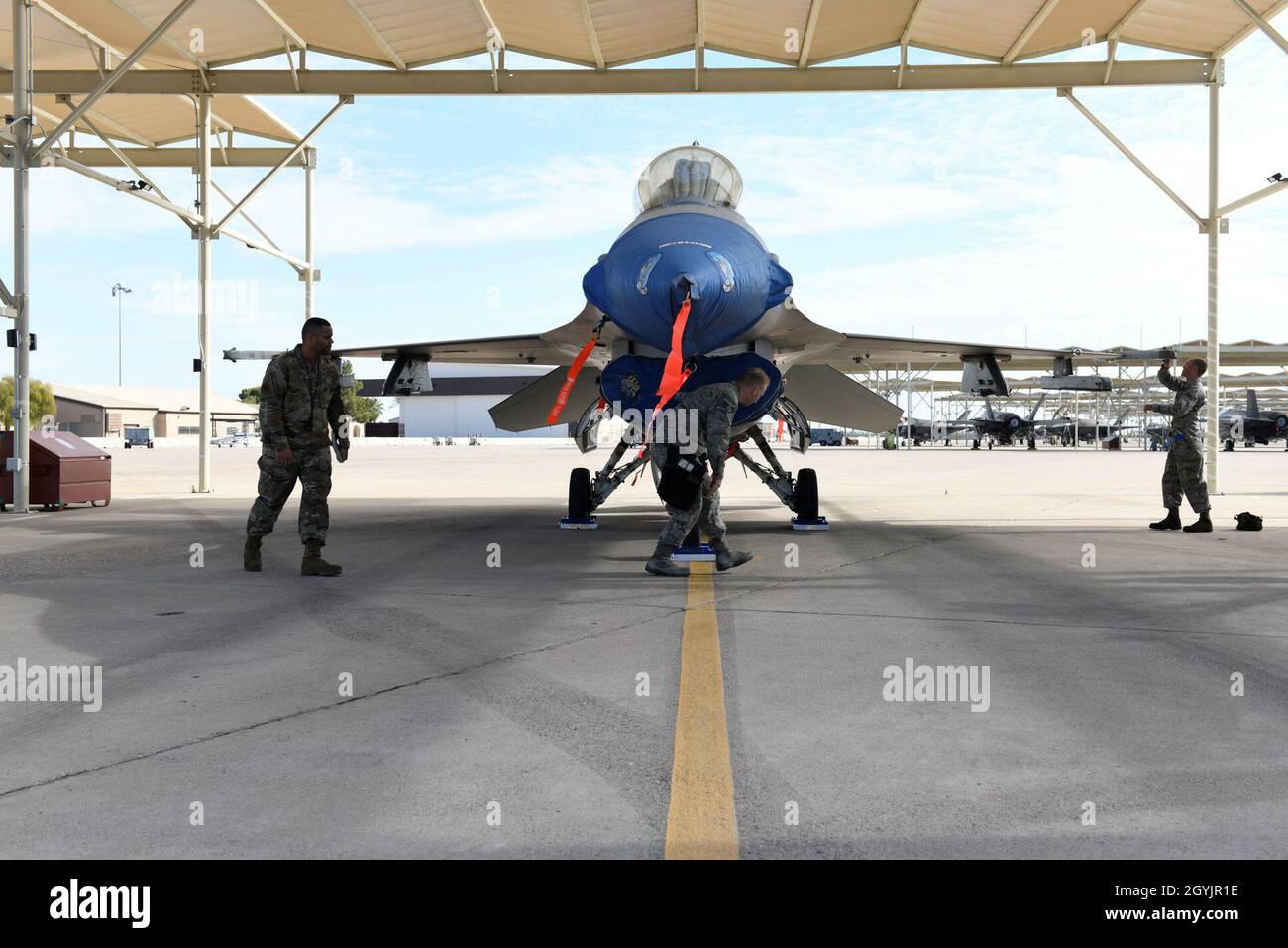 Airmen from the 309th Aircraft Maintenance Unit inspect an F-16 ...