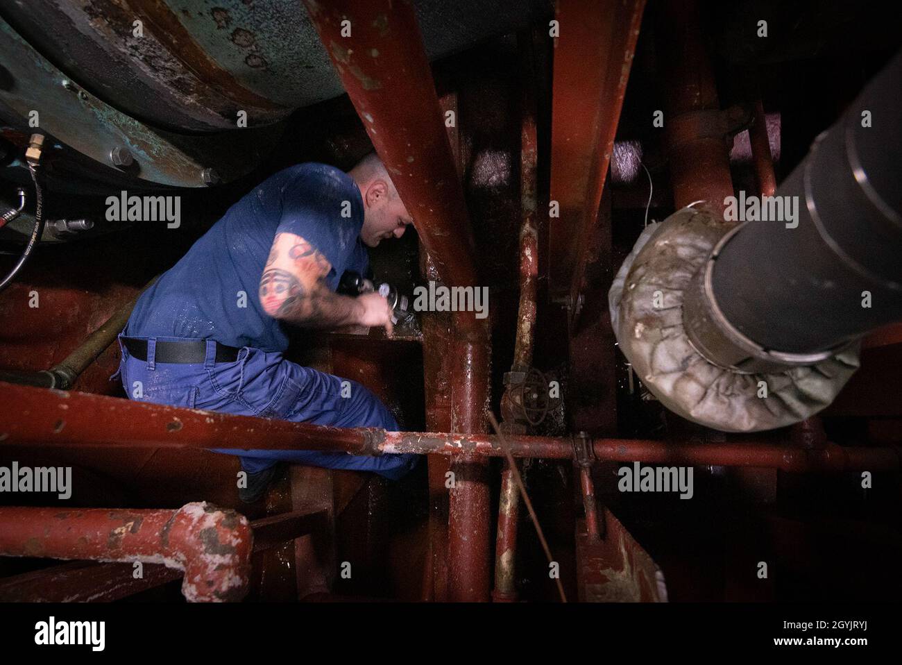 U.S. Coast Guard Petty Officer 2nd Class Dan Morales uses a water ram ...