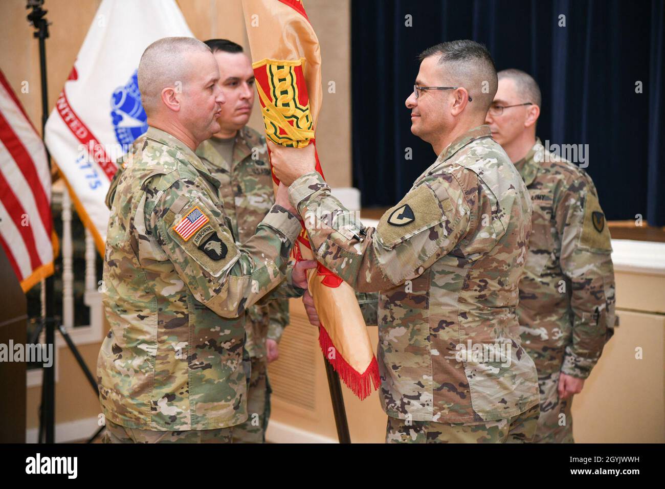 Outgoing Command Sgt. Maj. Roberto Marshall hands the unit colors to ...