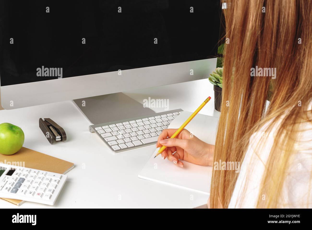 Woman making notes in notepad in an office Stock Photo - Alamy