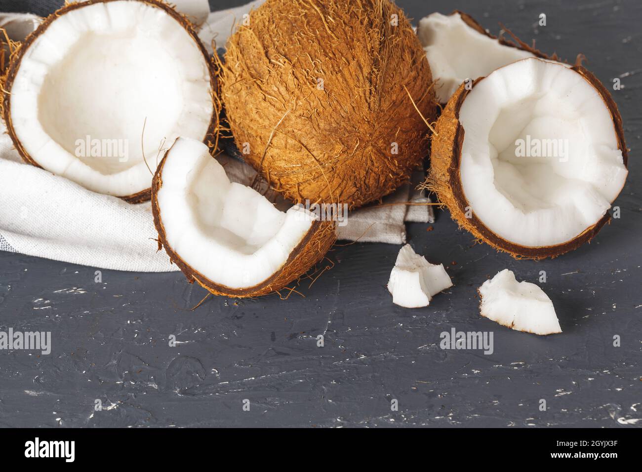 Pile of broken coconuts on ripped grey background Stock Photo - Alamy