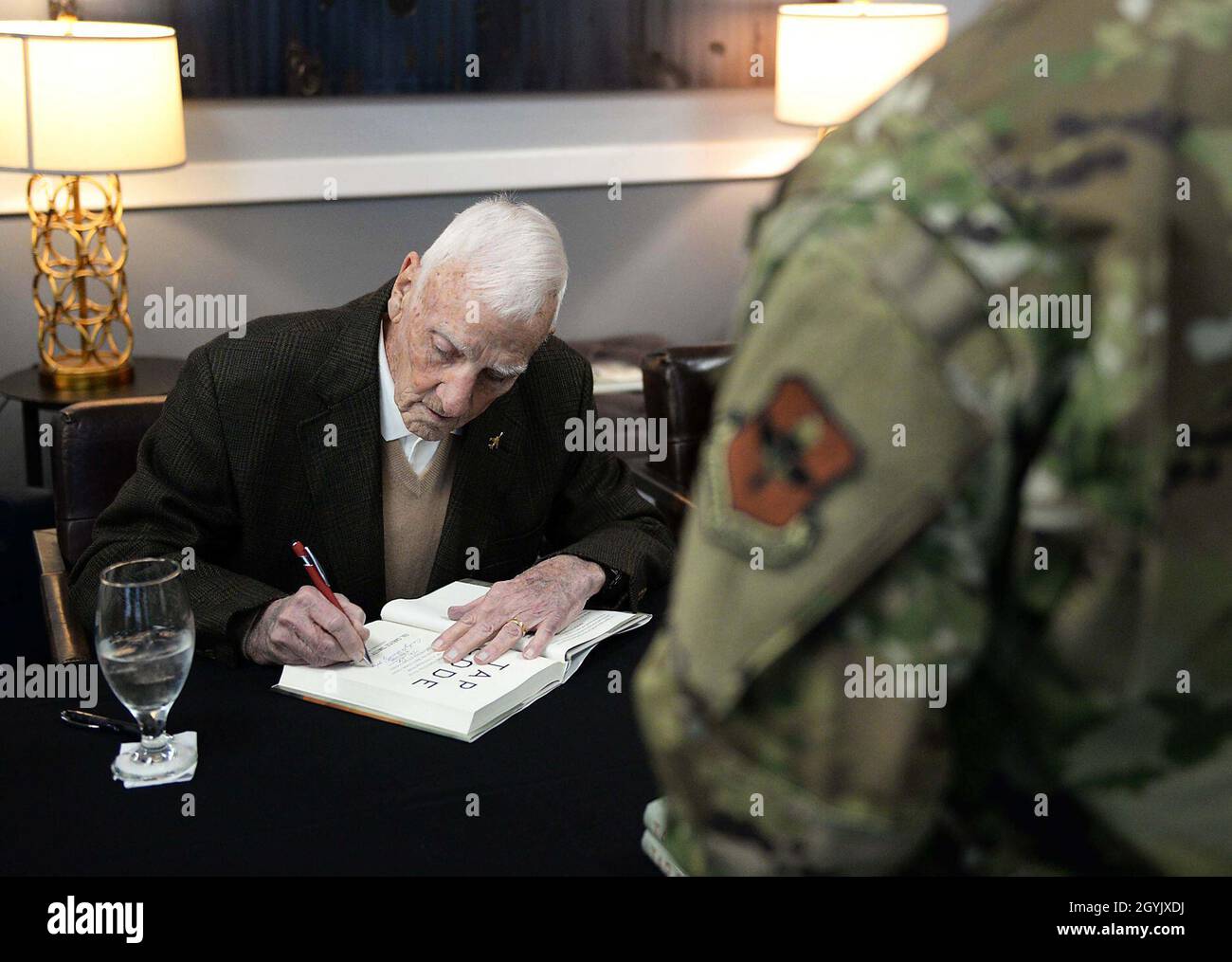 Retired Air Force Col. Carlyle “Smitty” Harris signs a book for an ...