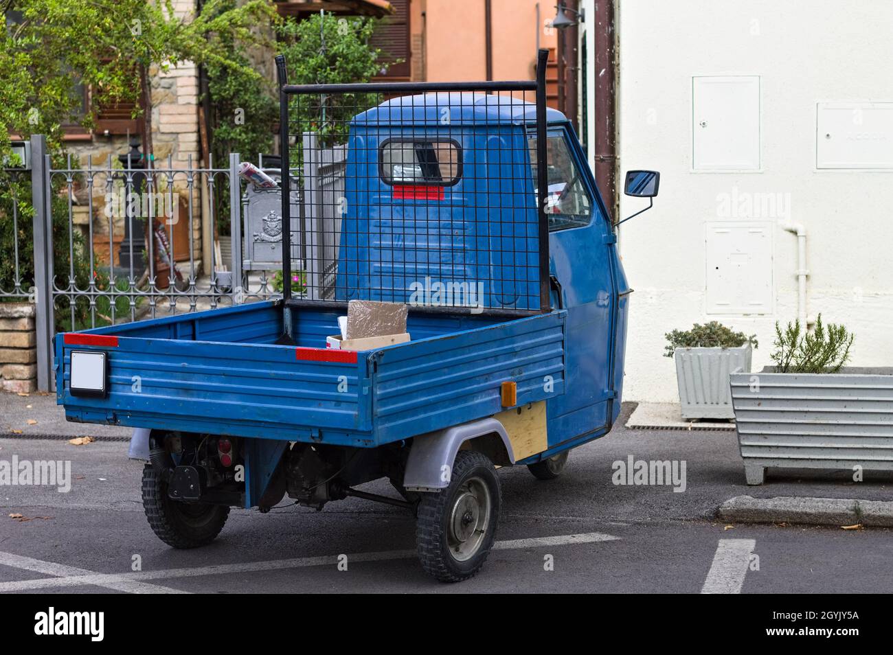 A traditional blue three-wheeled vehicle parked on the road (Tuscany ...