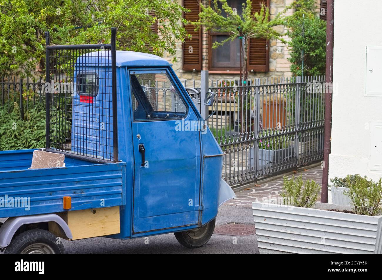 A traditional blue three-wheeled vehicle parked on the road (Tuscany ...