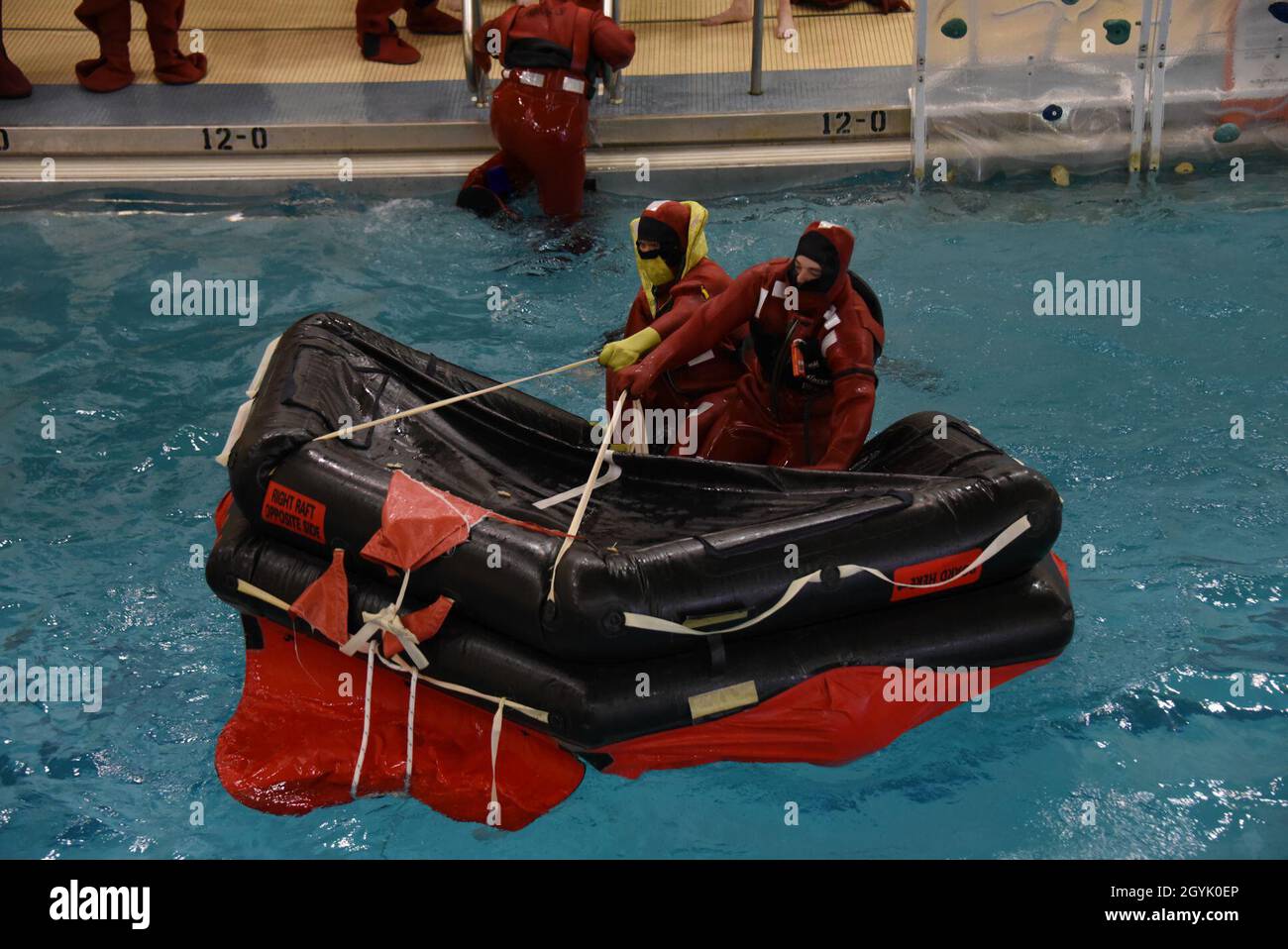 Two commercial fisherman work to right a raft as part of a refresher ...