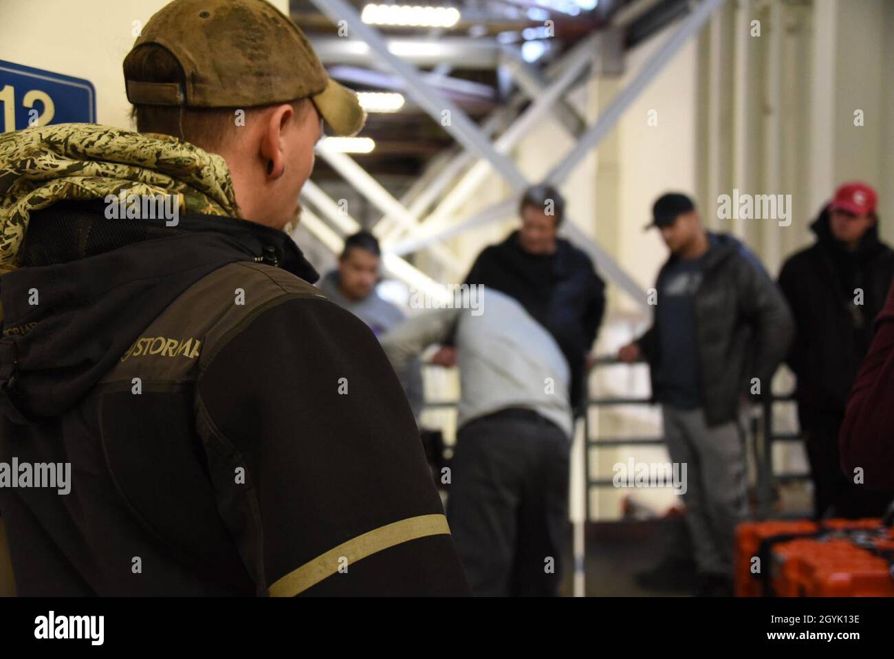A commercial fisherman listens as Coast Guard Petty Officer 1st Class ...