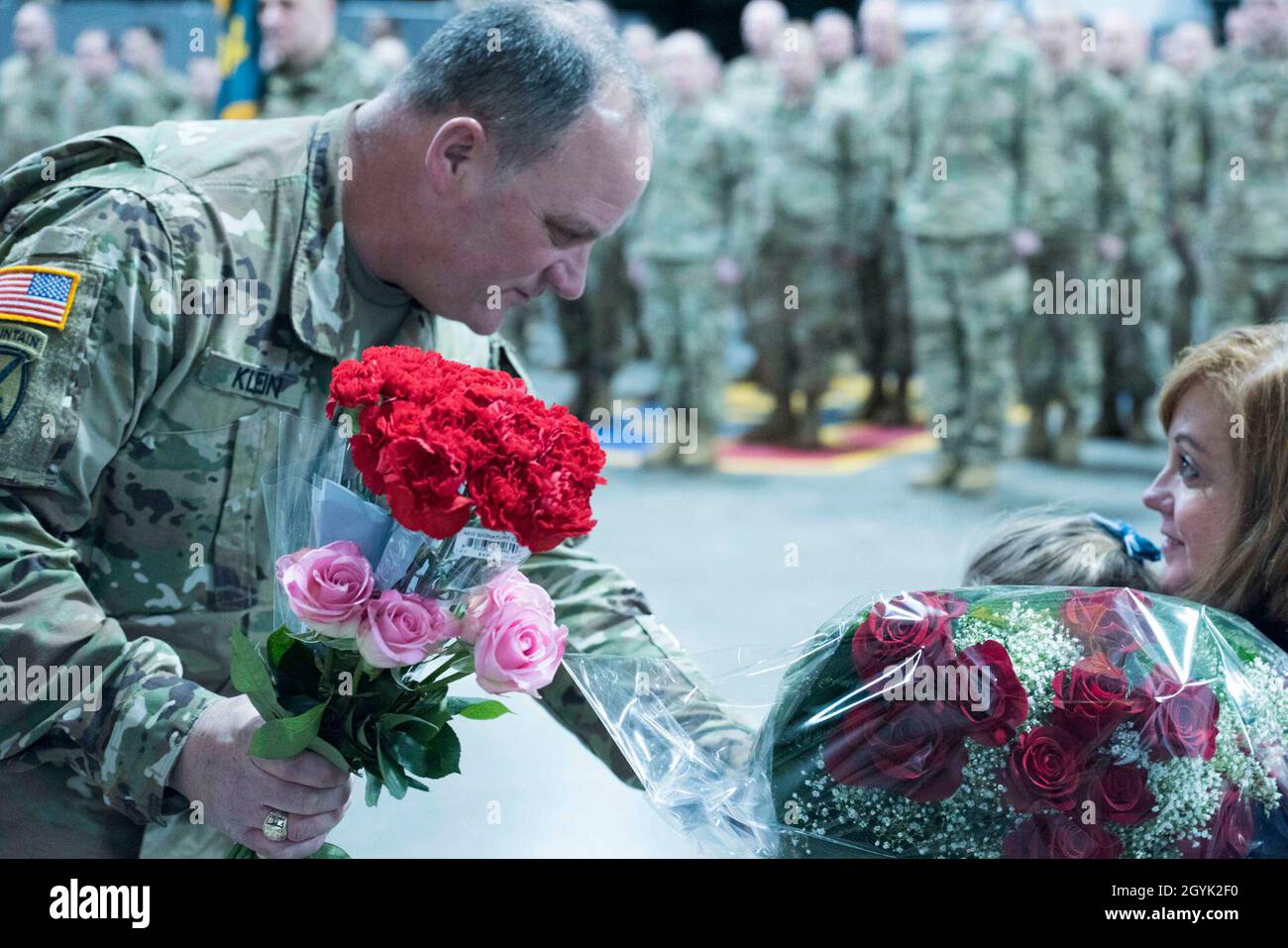 U.S. Army Command Sgt. Maj. Gus Klein presents roses to his wife ...