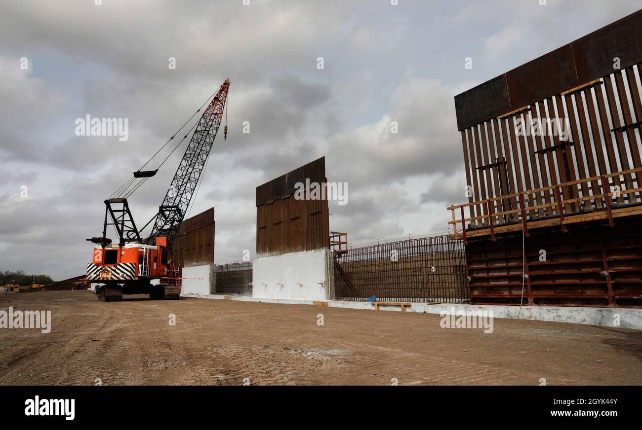 Construction crews work to erect levee wall system in a remote area ...
