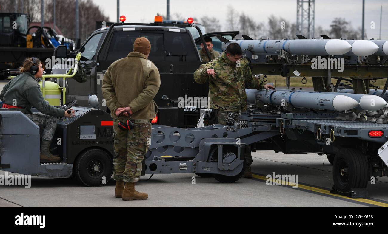 U.S. Air Force 52nd Fighter Wing weapons loaders pick-up an AIM-120 ...