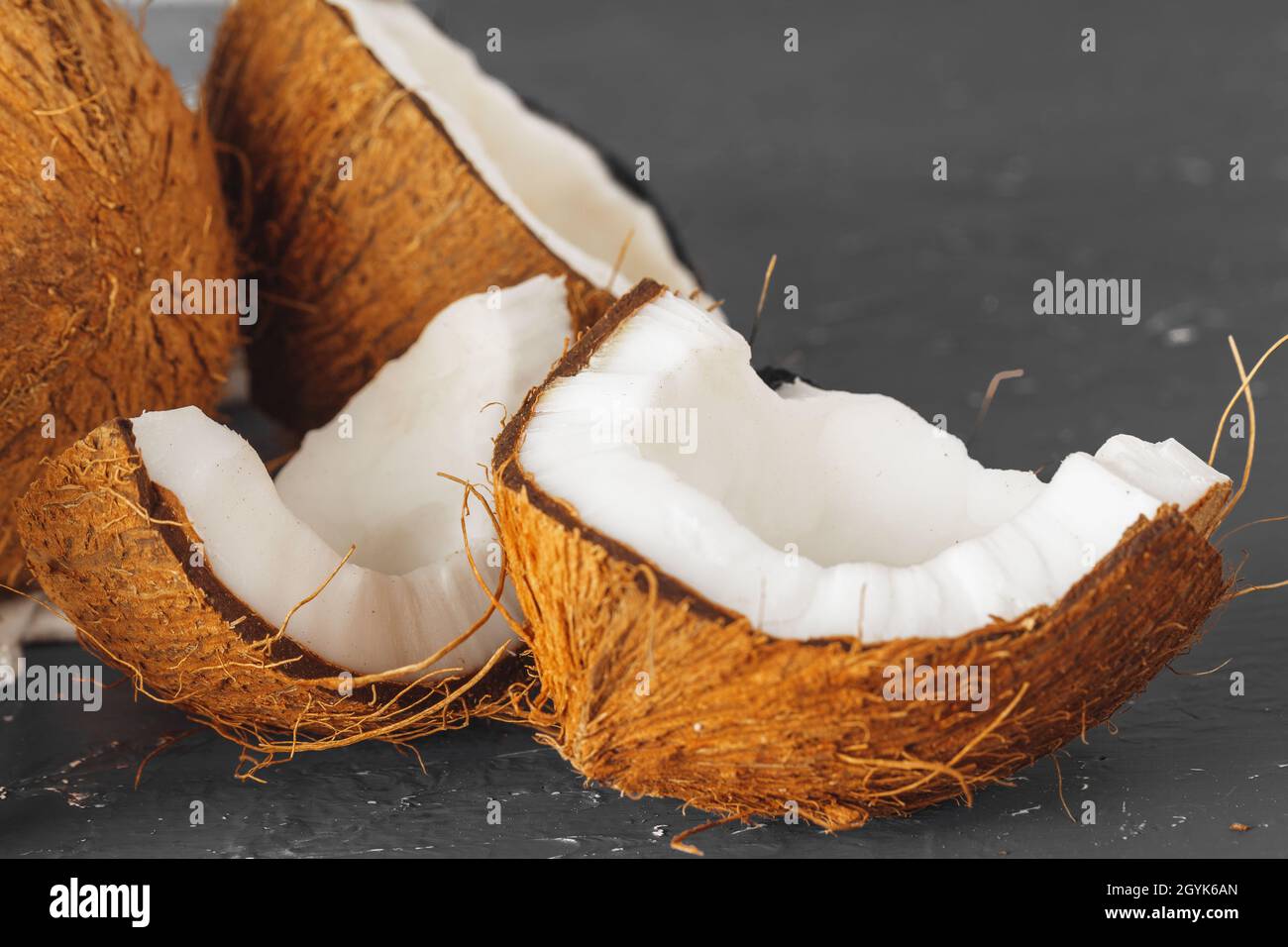 Pile of broken coconuts on ripped grey background Stock Photo - Alamy