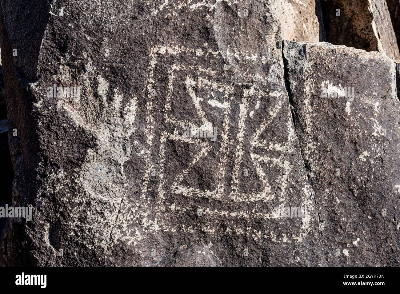 A footprint and a geometric design carved on a basalt boulder in the ...