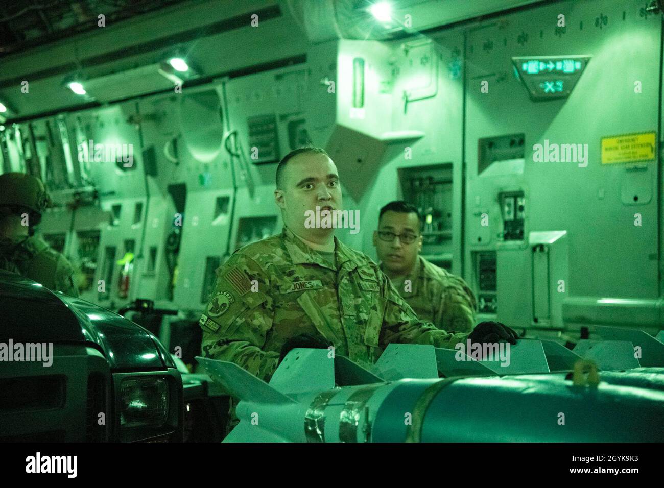 Senior Airman Eric Jones, 3rd Airlift Squadron loadmaster, directs the ...