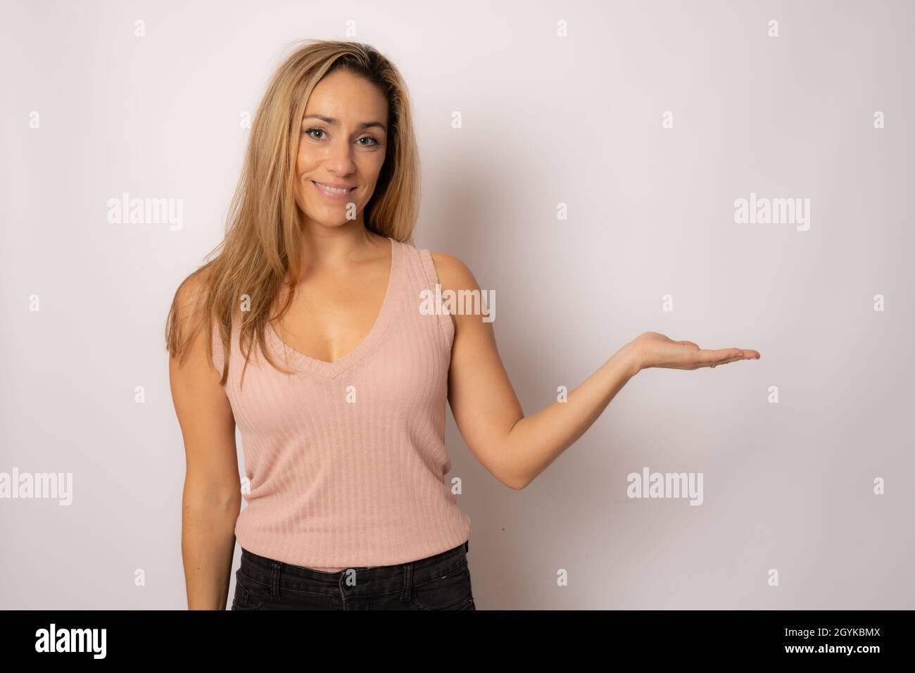Happy woman presenting with open hand holding something blank isolated ...