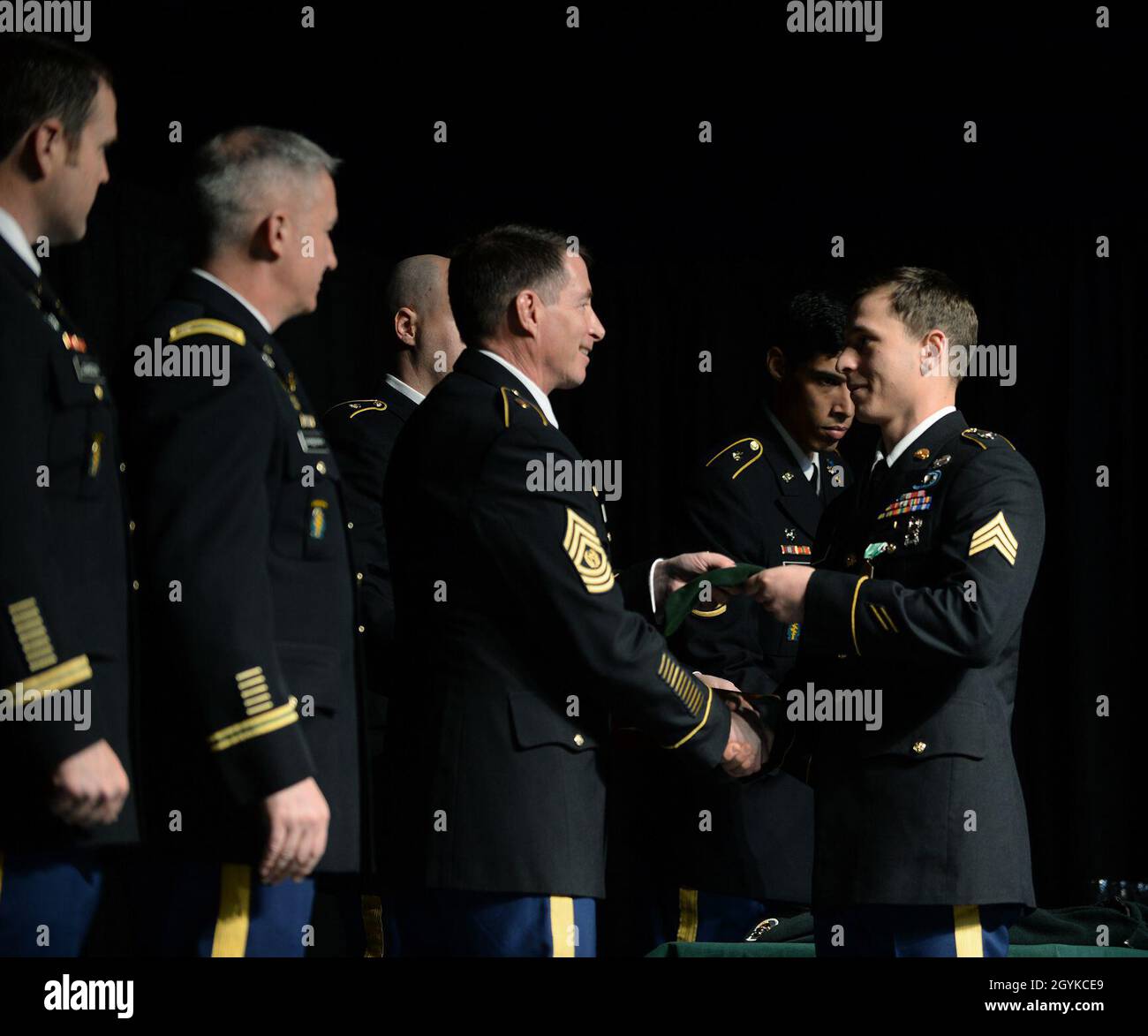Retired Command Sgt. Maj. Bill Thetford presents a green beret to a ...